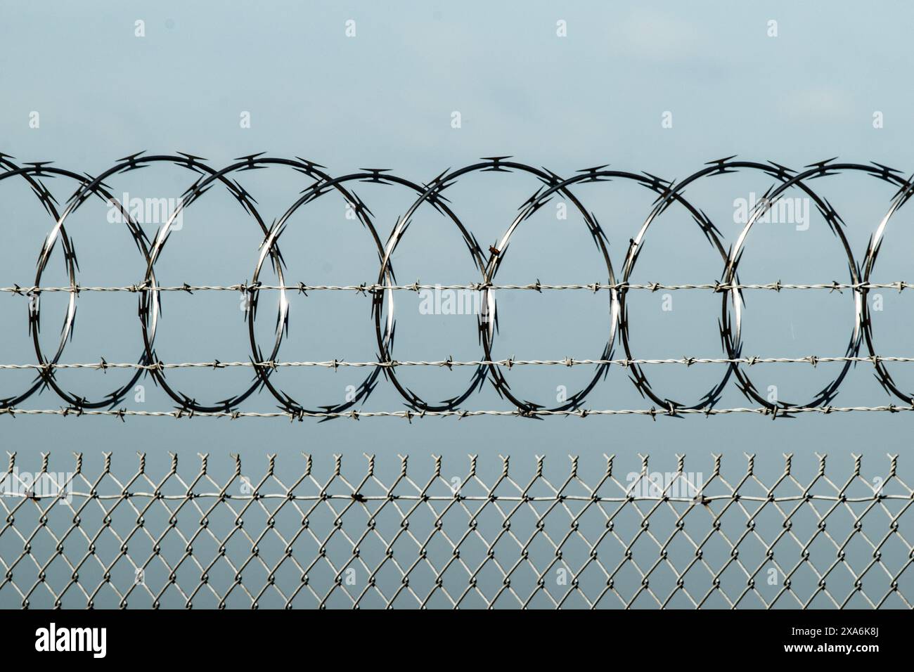 Razor wire atop chain link fence Stock Photo - Alamy