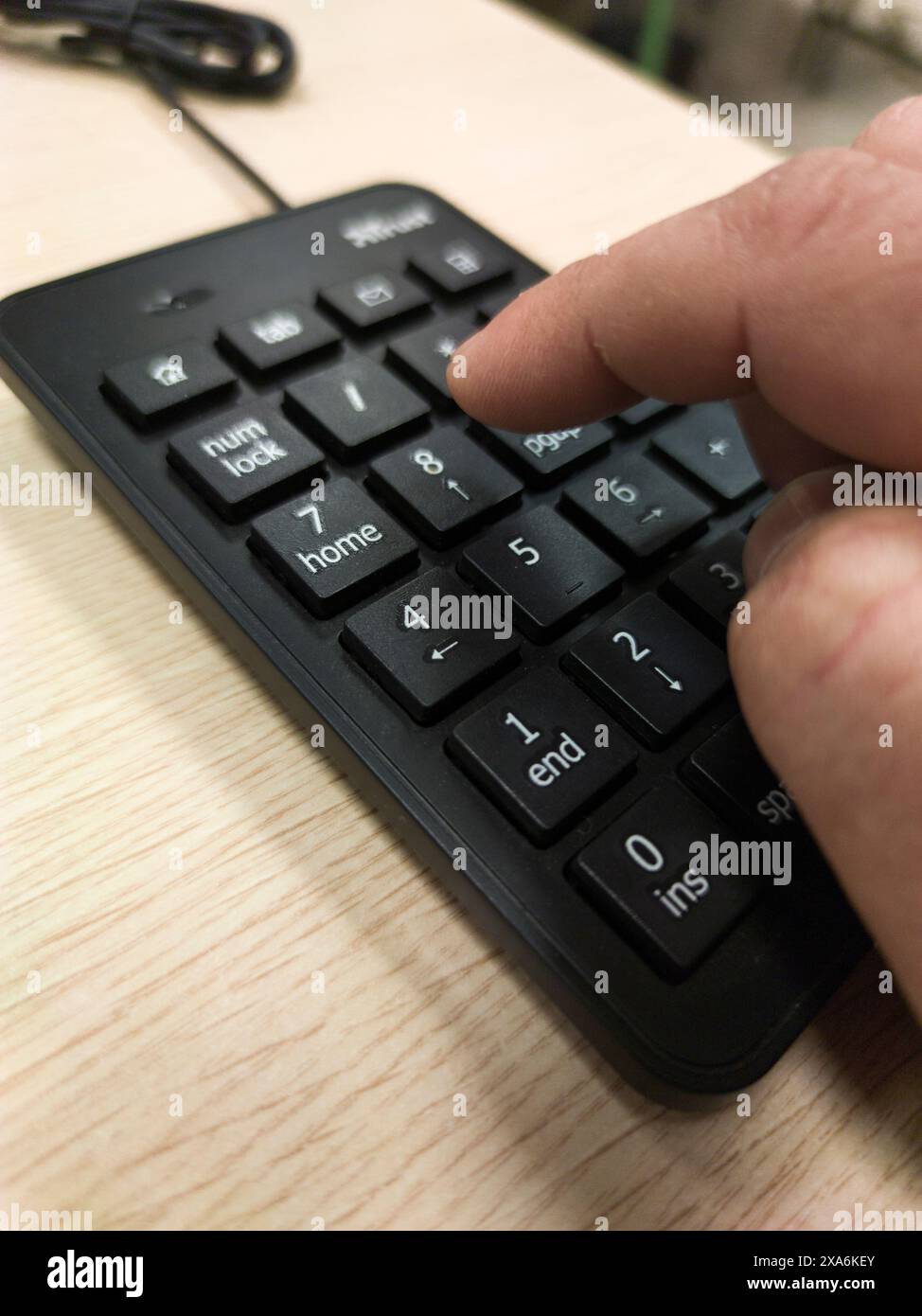 Mature mans hand pressing a numeric keypad. Wooden surface Stock Photo ...