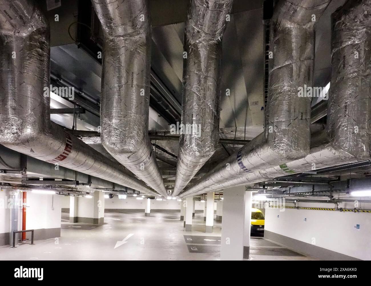 A Couple of supply lines attached under the ceiling in a parking garage ...
