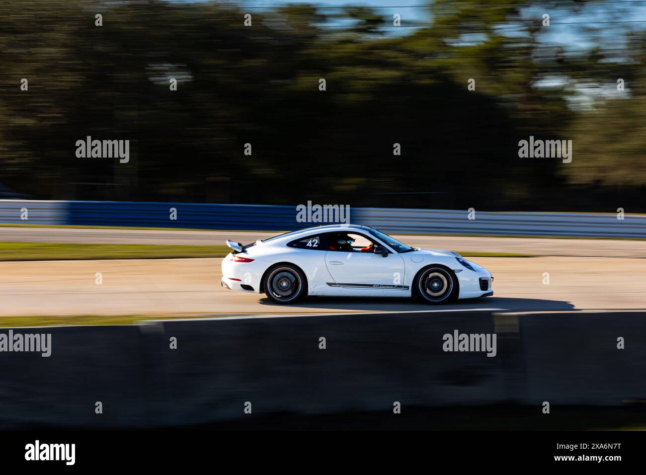 A white Porsche 911 racing on a track at high speed in Sebring, United ...