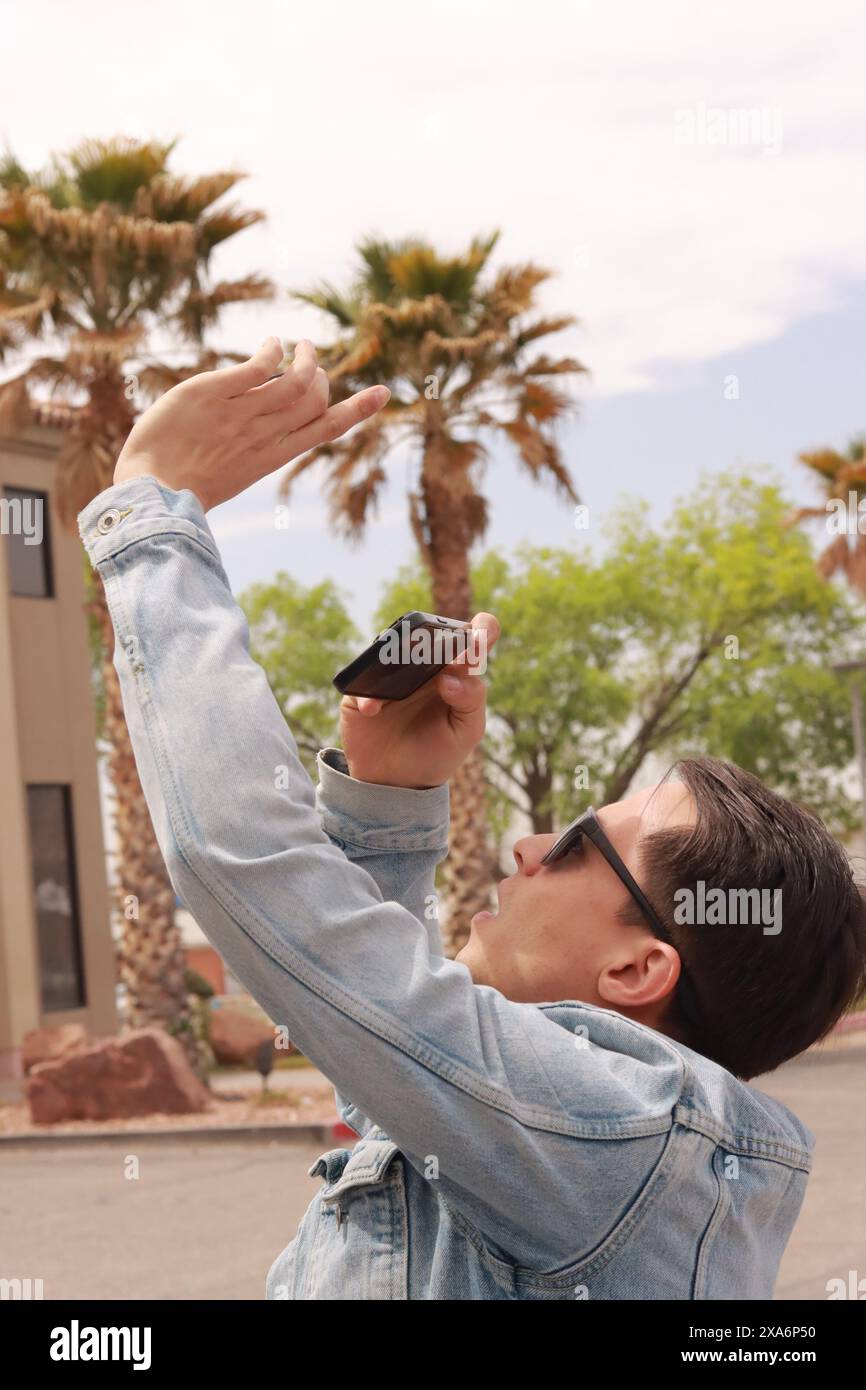 A young man looking at the sun and taking photos during a solar eclipse ...