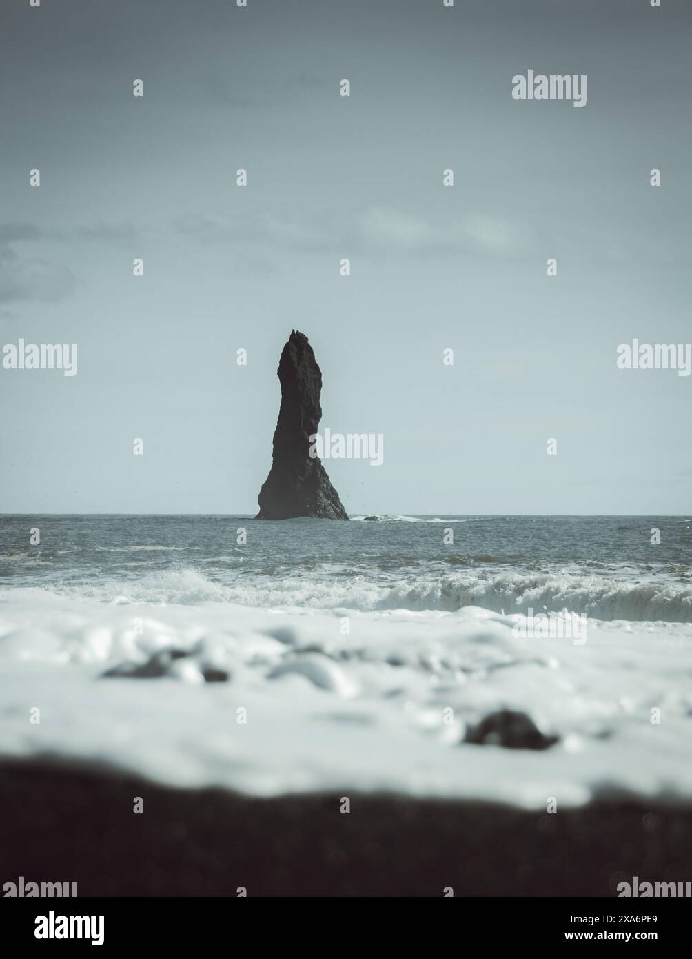 The majestic basalt rock of Reynisfjara emerging from the ocean, a ...