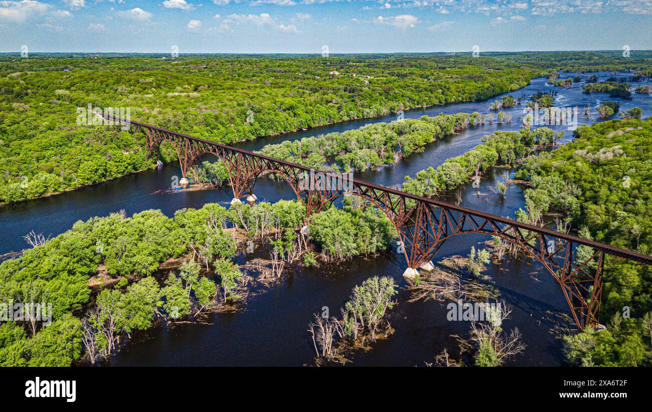 Tranquil river flowing through rural landscape with trees and bushes in ...