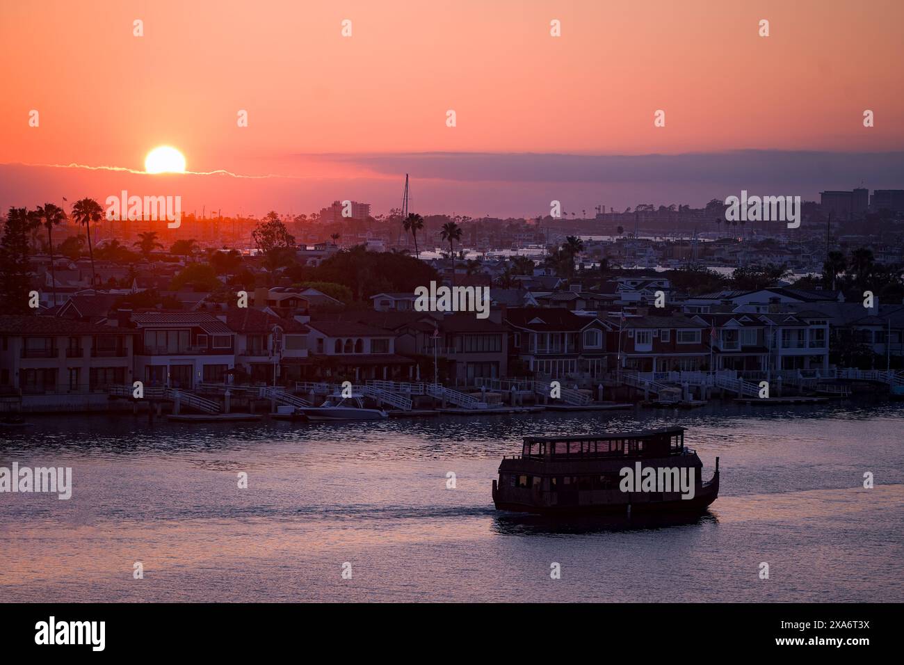 A ferry cruises on water at sunset Stock Photo - Alamy
