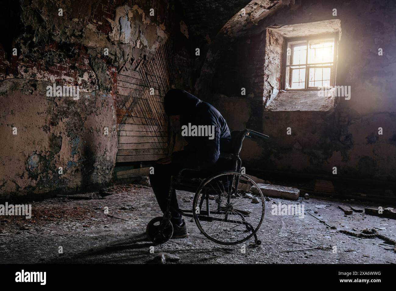 Sad man sitting in old wheelchair in abandoned hospital ward. Person ...
