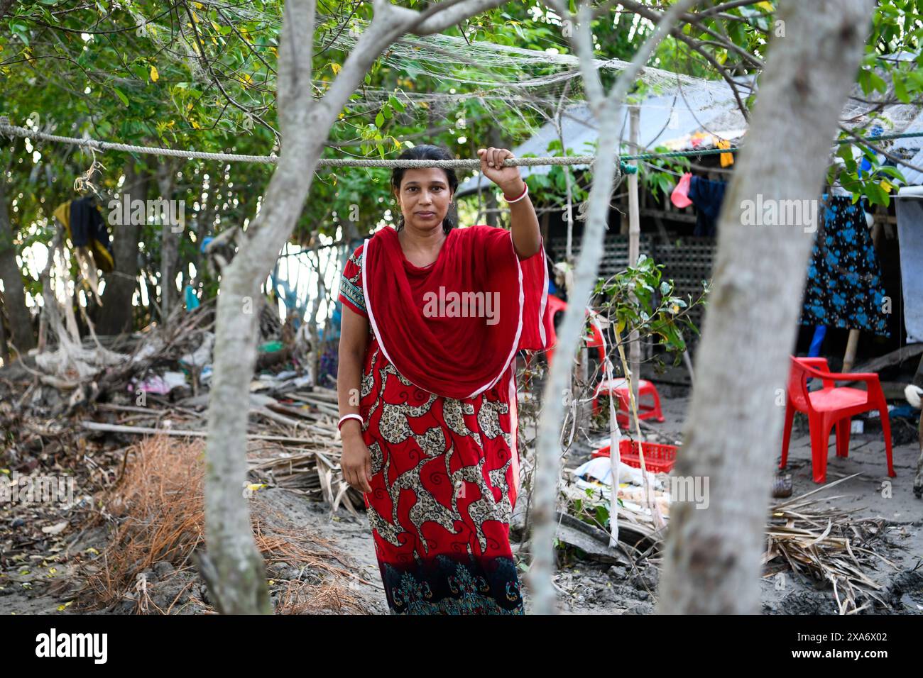 A woman stands at a damaged home during the aftermath in Mongla ...
