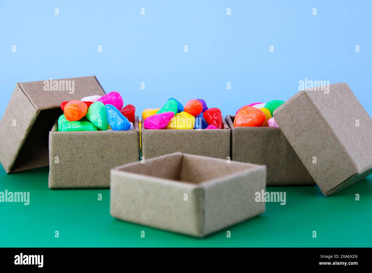 Three cardboard boxes containing colorful stones Stock Photo - Alamy