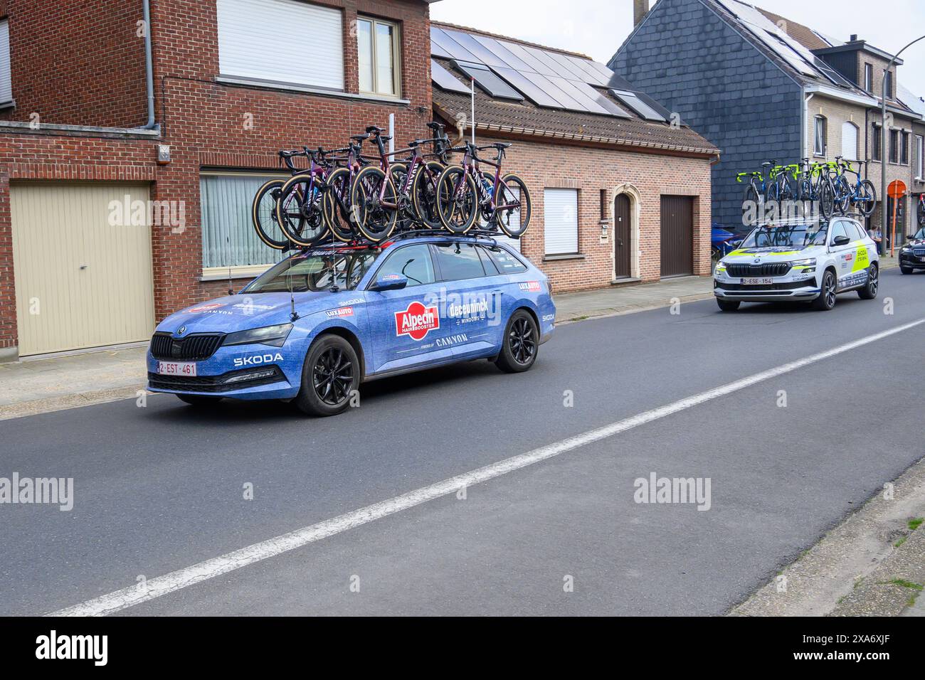 A Blue car with roof bike racks driving down the street in a cycling ...