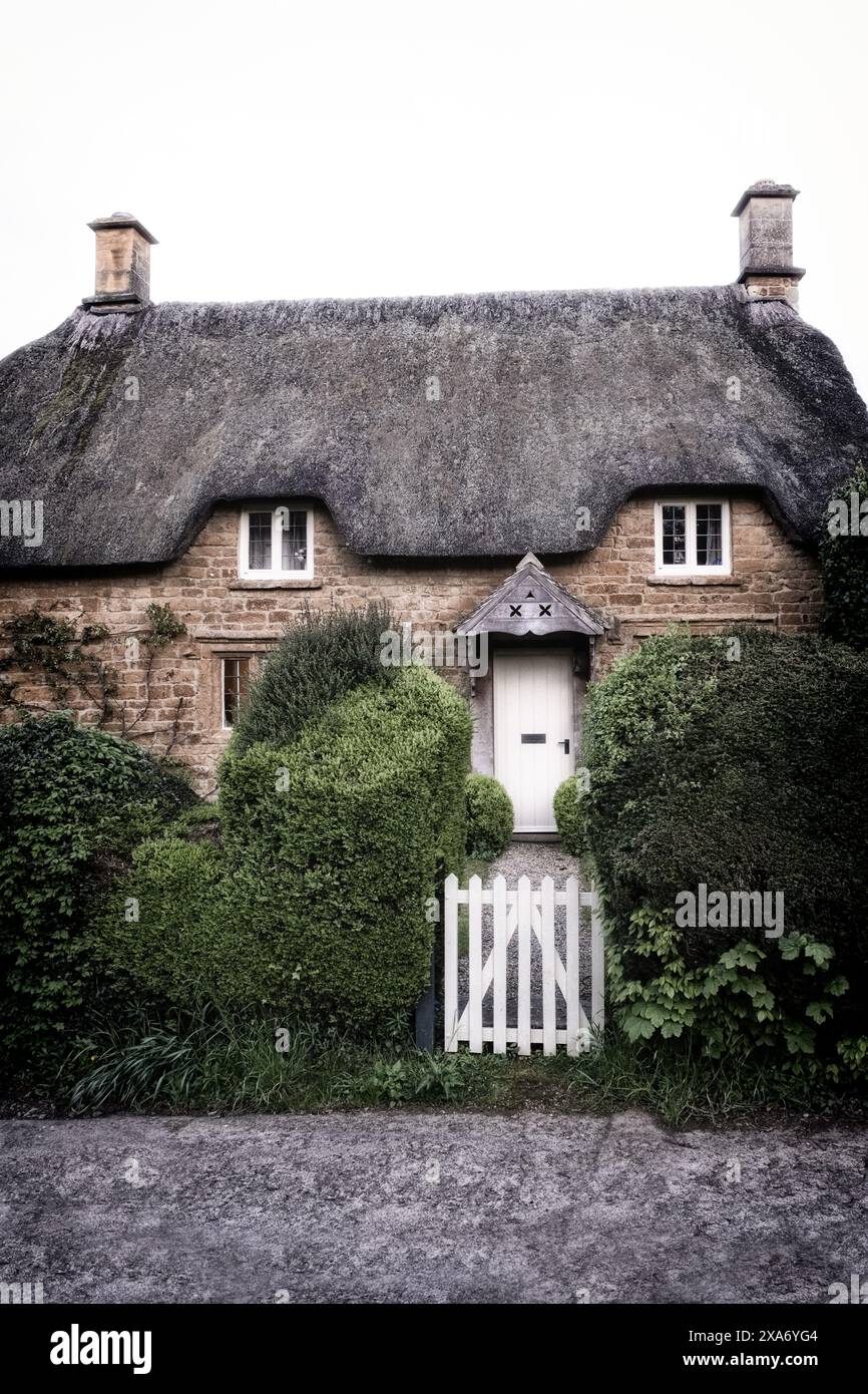 A small house surrounded by bushes and shrubs outdoors Stock Photo - Alamy
