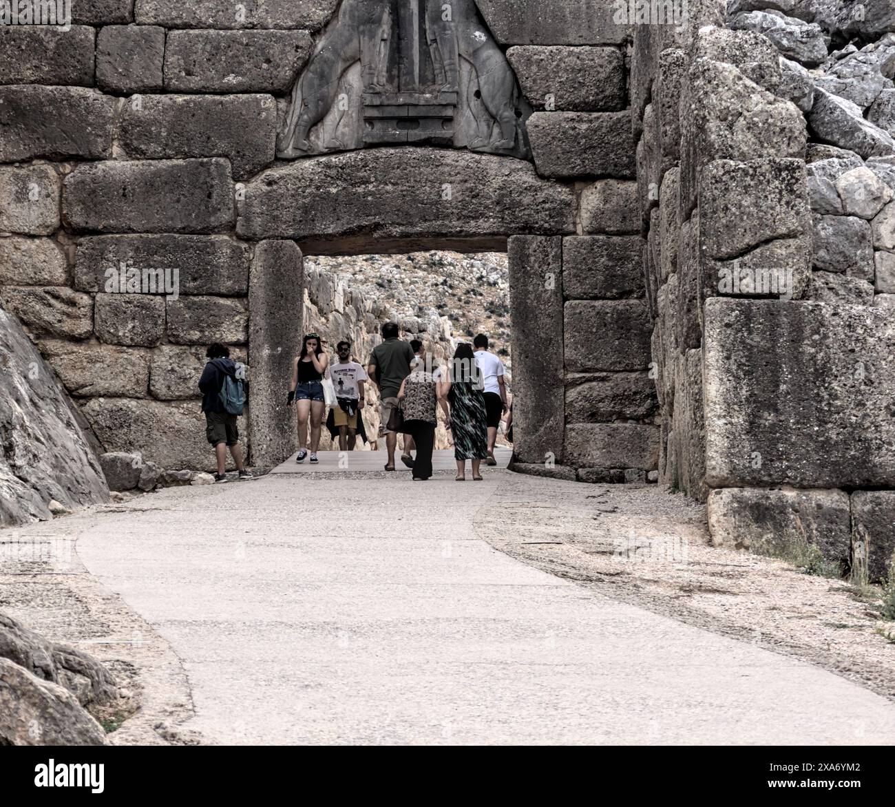Tourists pass through Lions' Gate entrance at the famous ancient Greek ...