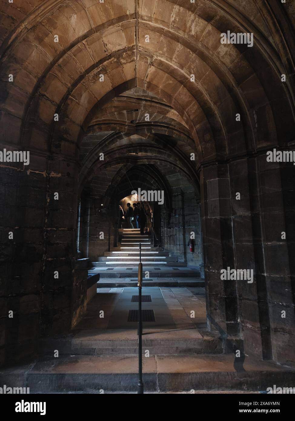 A narrow walkway with arched walls leading to buildings Stock Photo - Alamy