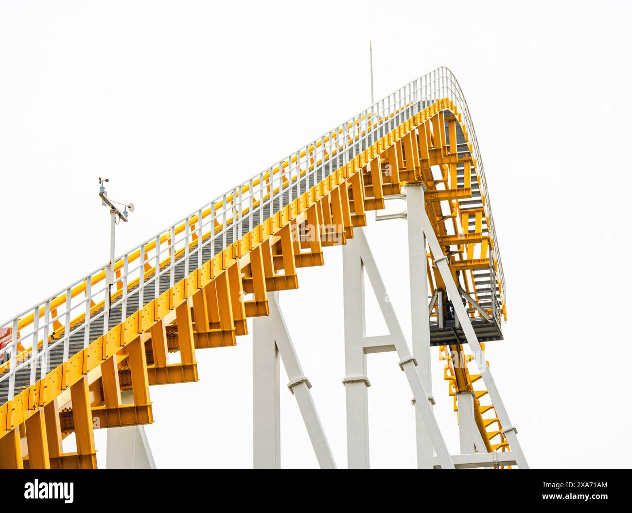 A thrilling yellow and white roller coaster descending on an amusement ...