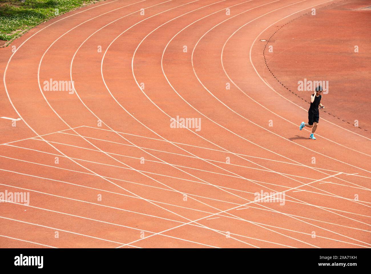 A man jogging on an empty outdoor track at night Stock Photo - Alamy