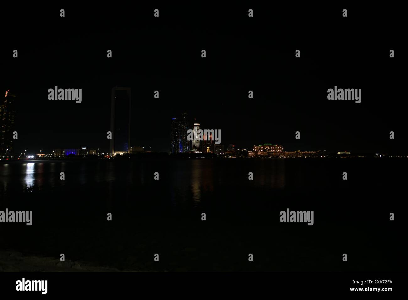 City skyline at night seen from the water, featuring illuminated ...