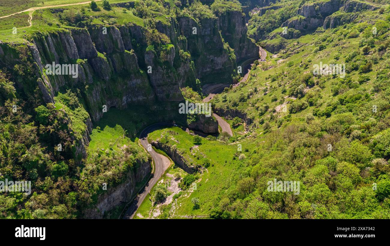 Scenic valley with lush green cliffs, rocks, water, and road Stock ...