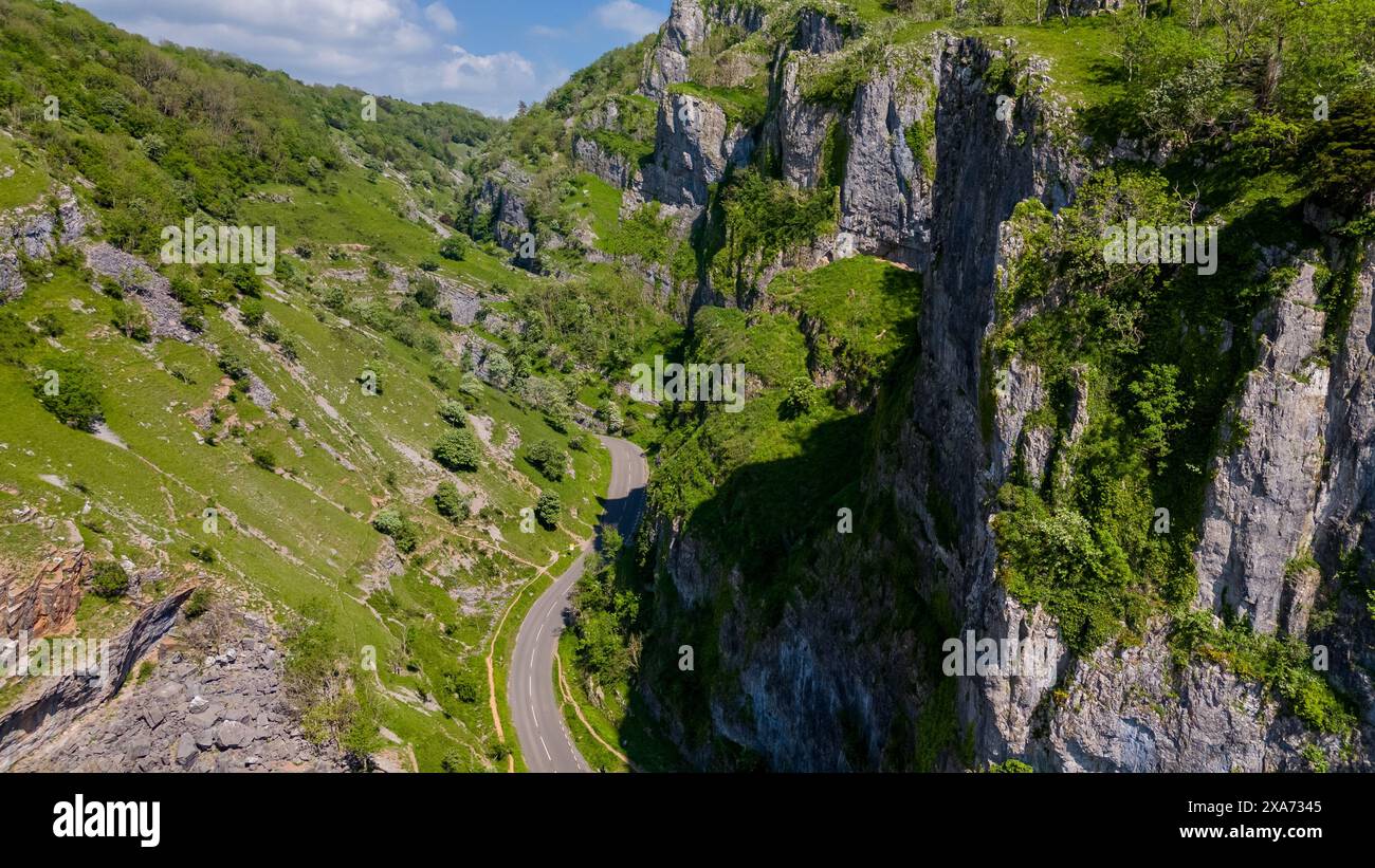 Curving road on steep mountain cliff in valley Stock Photo - Alamy