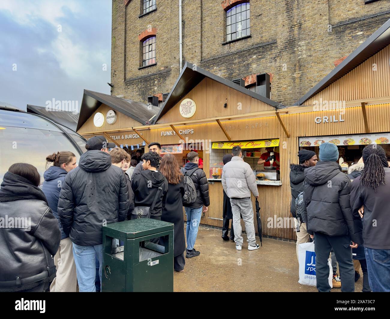 A group of people waiting in line at a food stall Stock Photo - Alamy