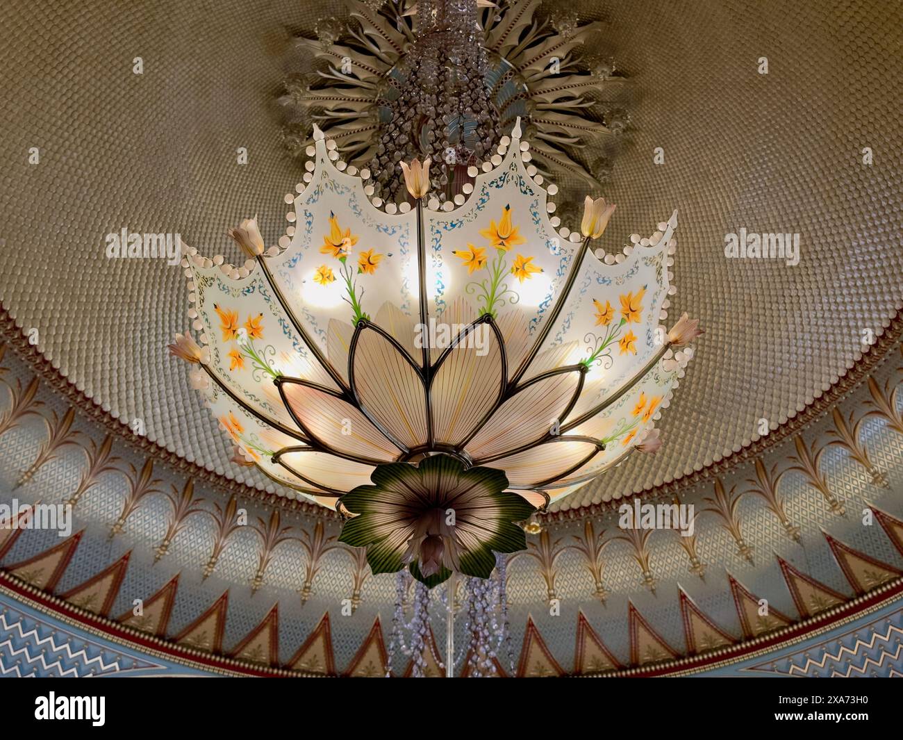 Chandelier with blue floral design hanging from ceiling in building ...