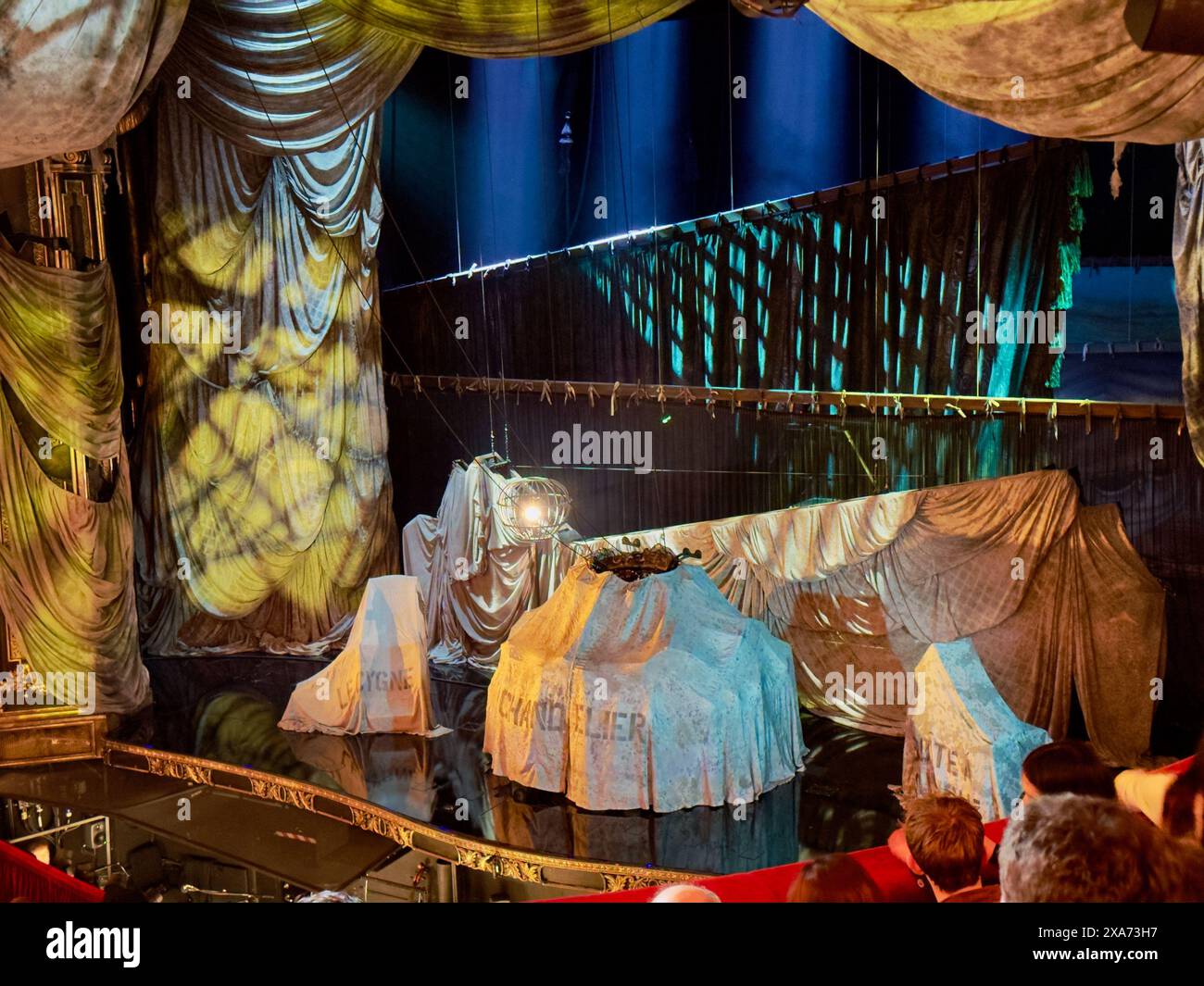 Actors performing on stage with fabric draped over them in a theatrical ...
