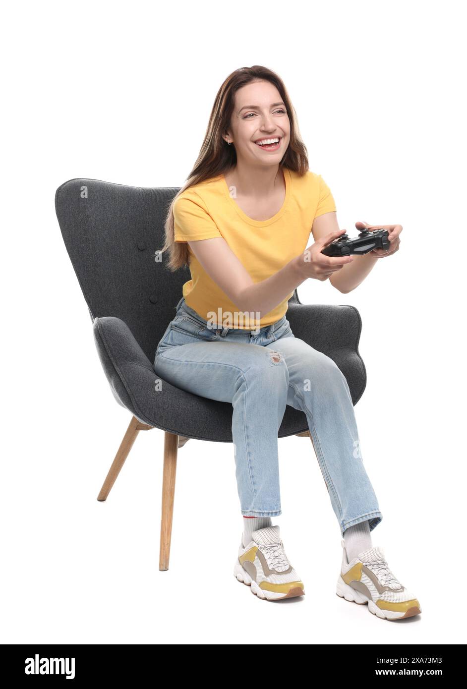 Happy woman with game controller sitting in armchair on white ...