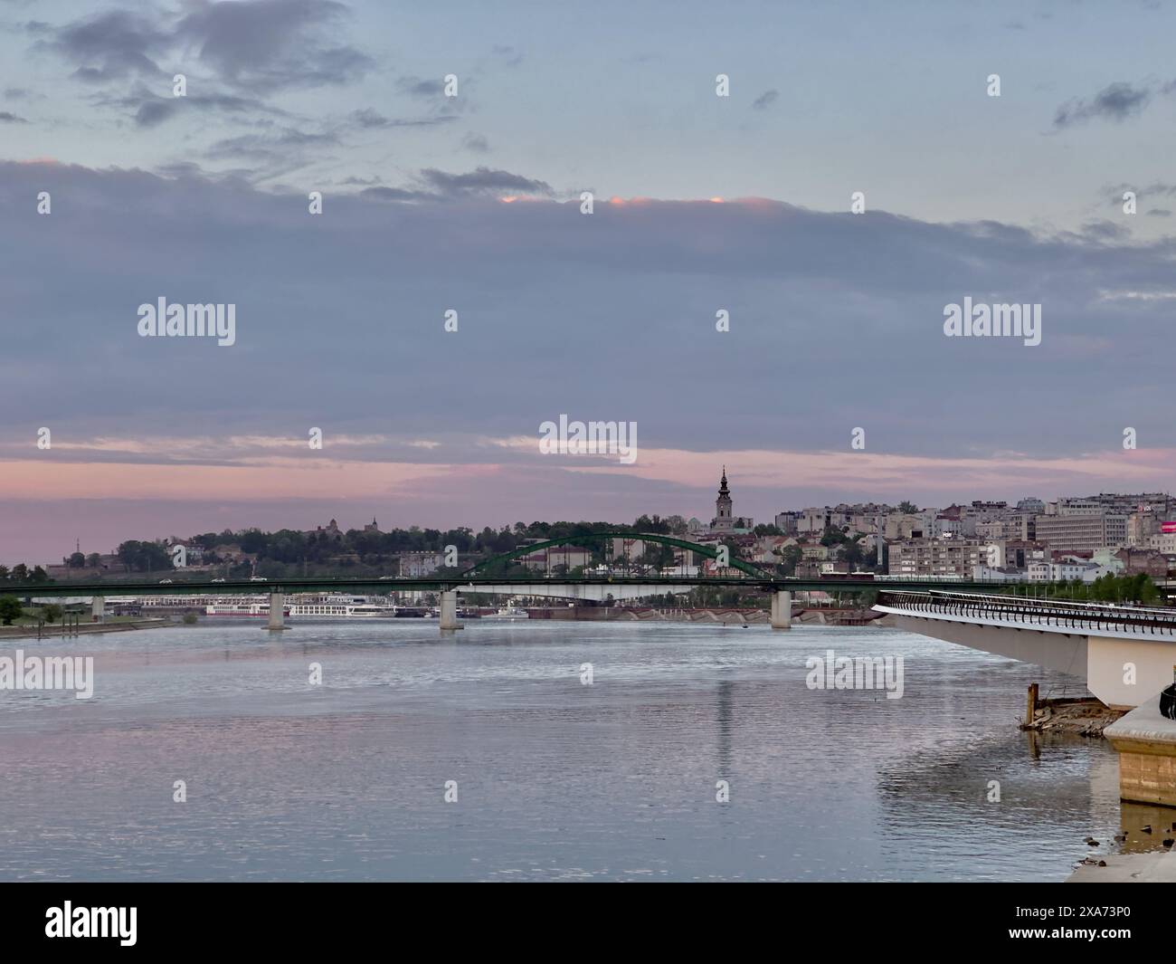 Individuals seated on benches by the water, gazing at the city skyline ...