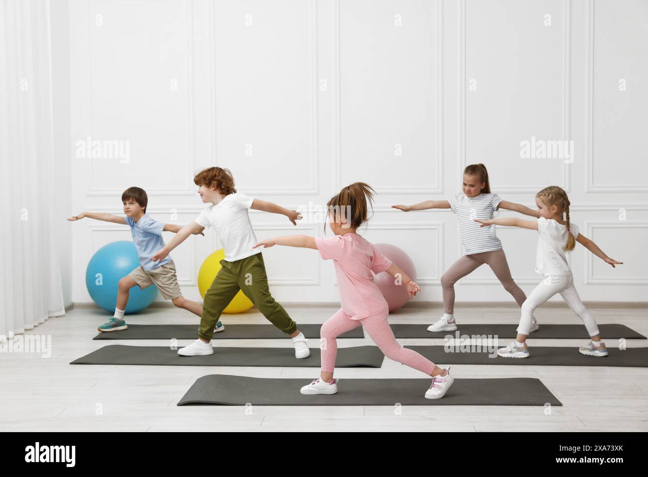 Group of children doing gymnastic exercises on mats indoors Stock Photo ...