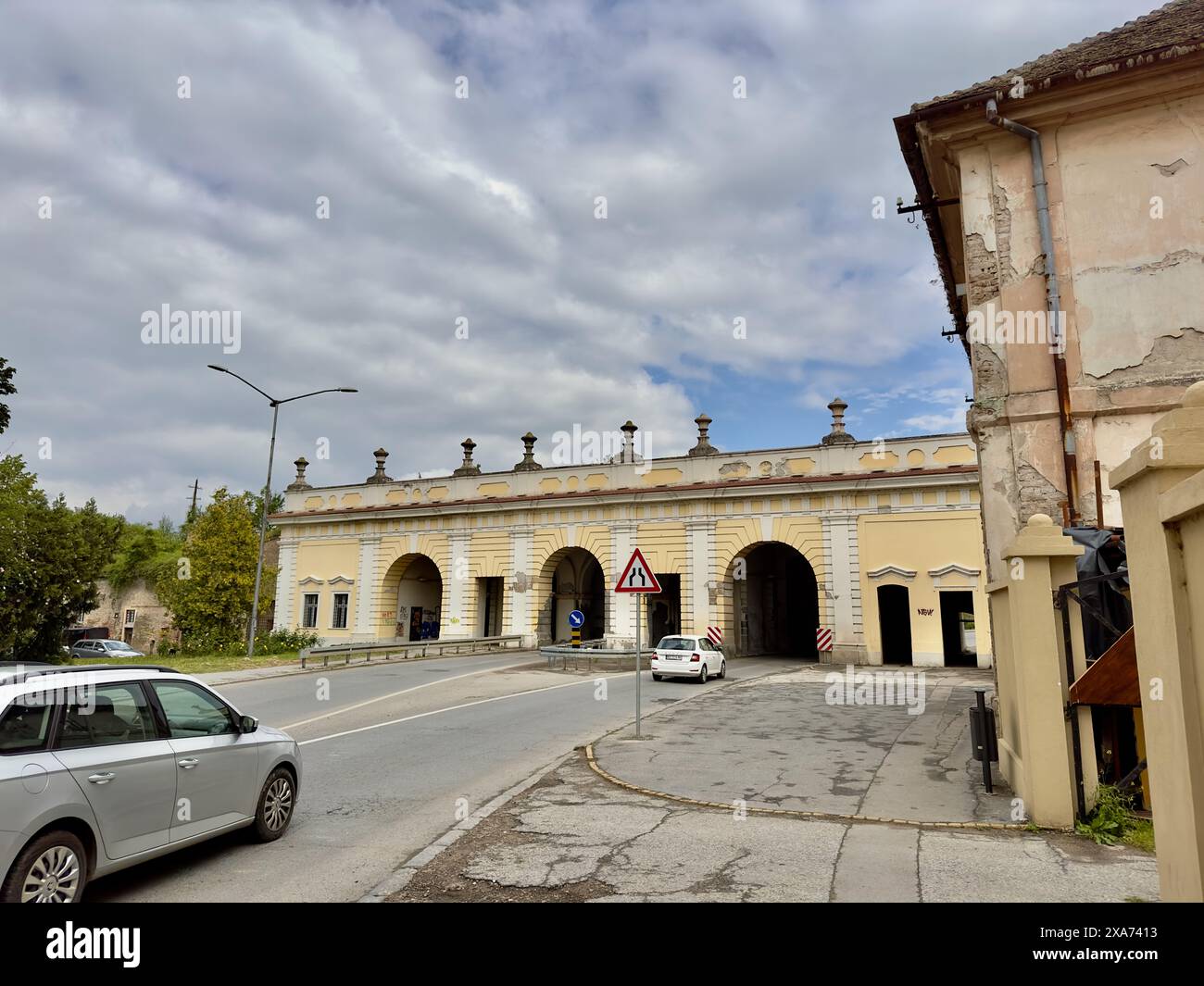 A car parked by a road flanked by two buildings and a street light ...