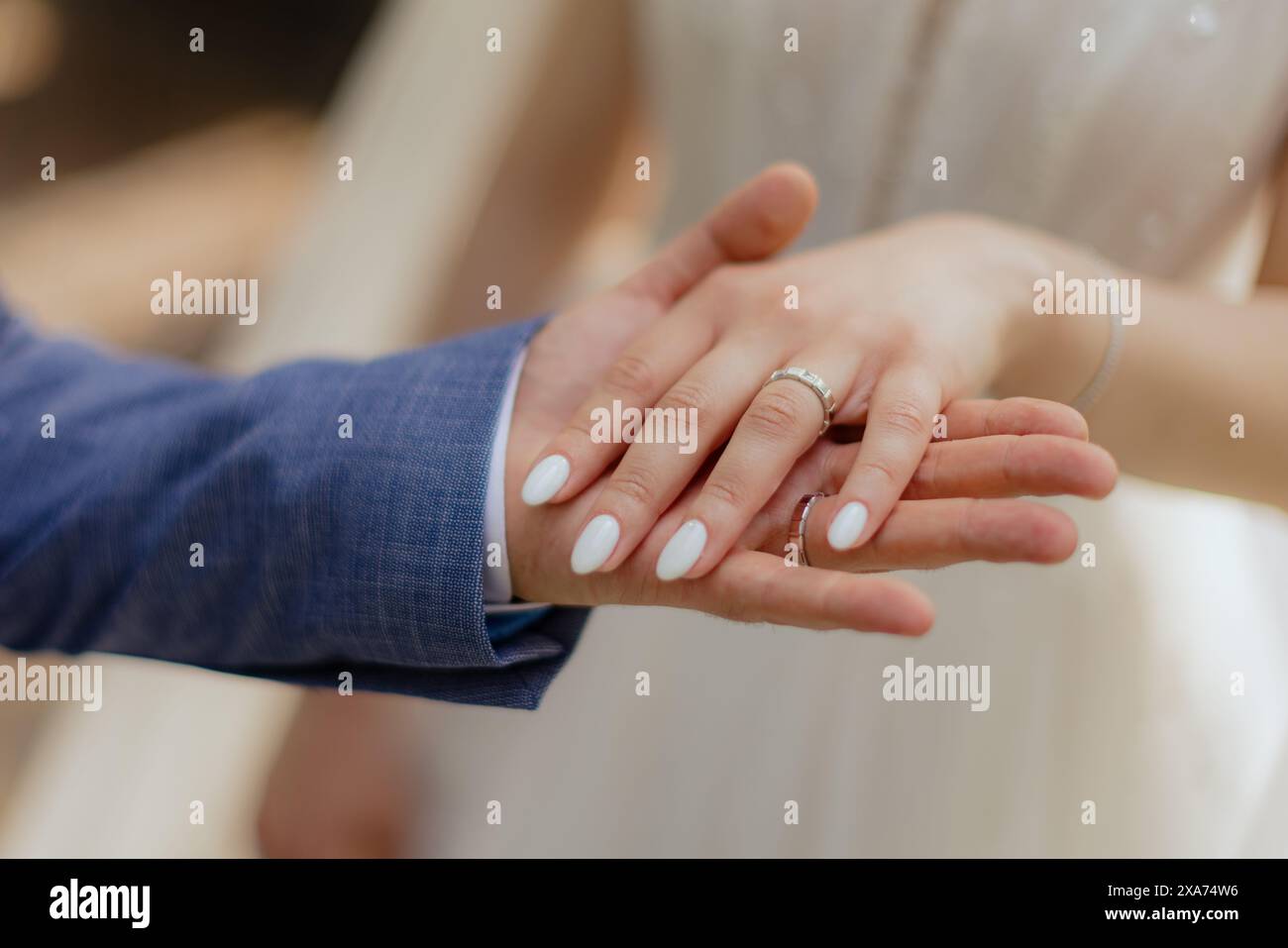 Two people, one in formal attire, holding hands affectionately Stock ...