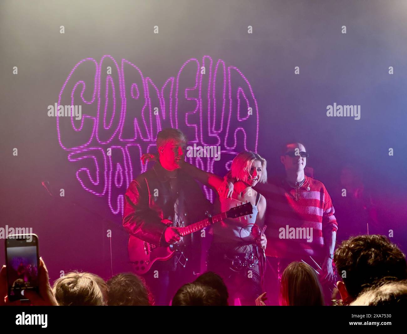 A band performing on stage with a crowd and spectators nearby Stock ...