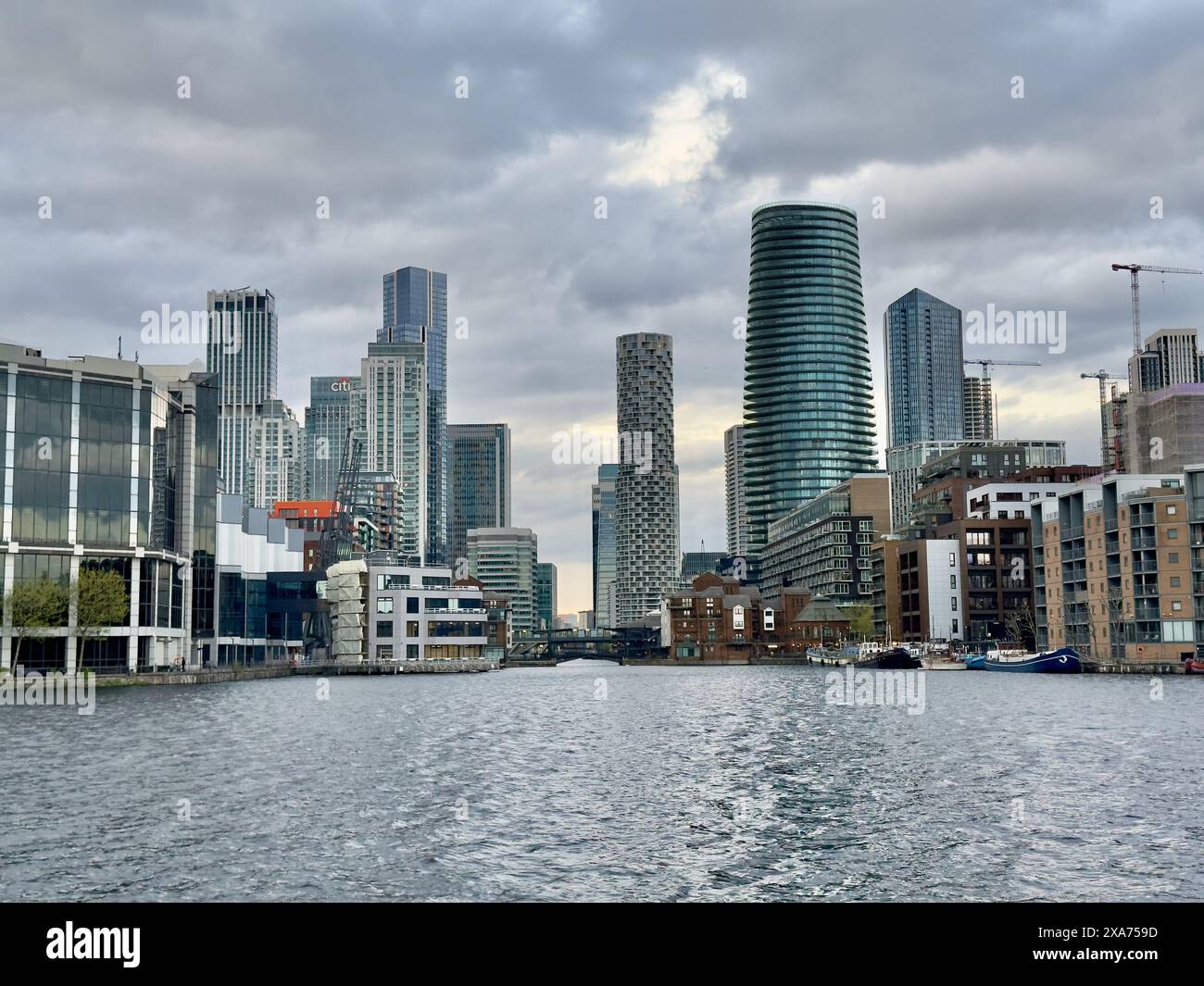 Multiple boats on a river with tall buildings in the background Stock ...