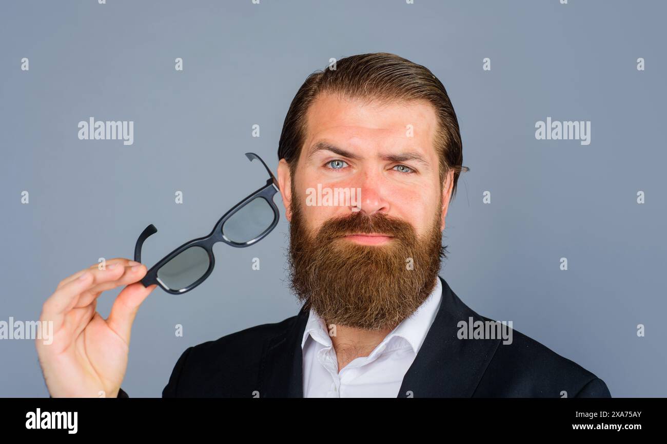 Portrait of serious bearded man takes off sunglasses. Handsome man in ...