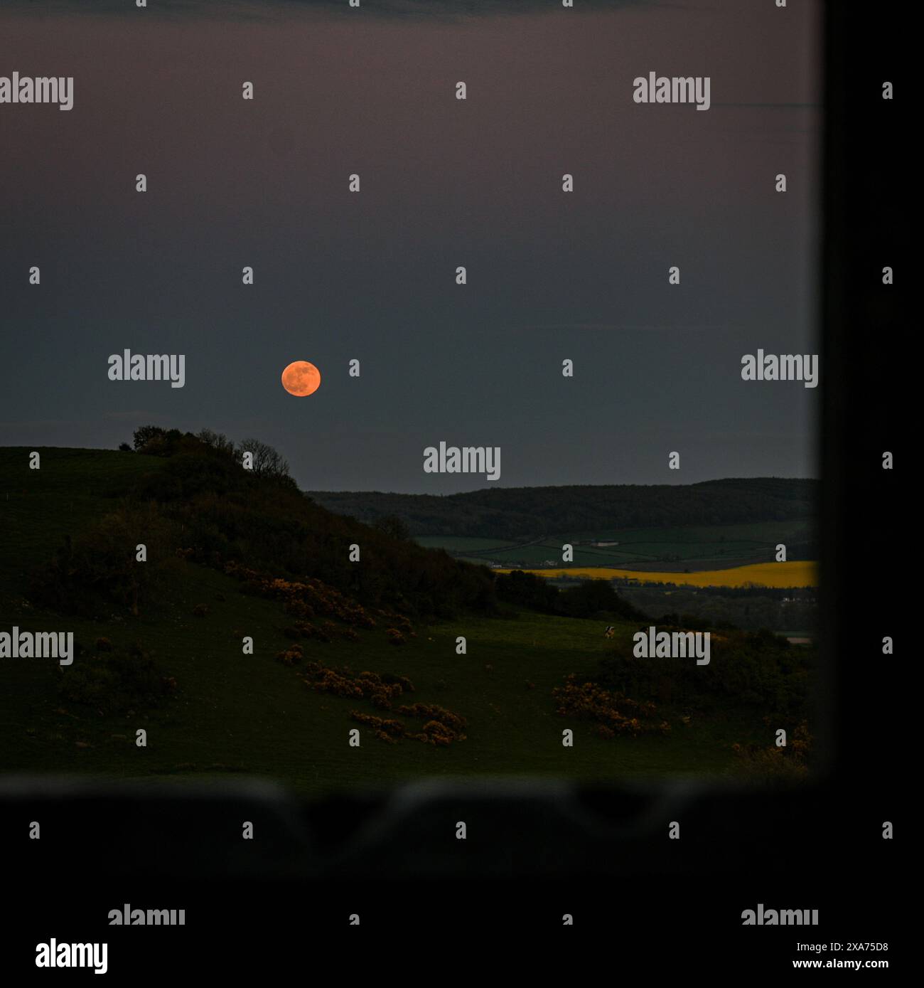 View of moon through window, above lush green hillside Stock Photo - Alamy