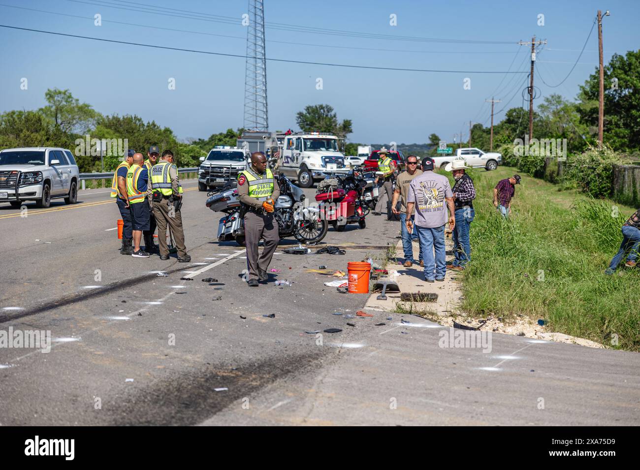 A group of people standing on the road near vehicles after an accident ...
