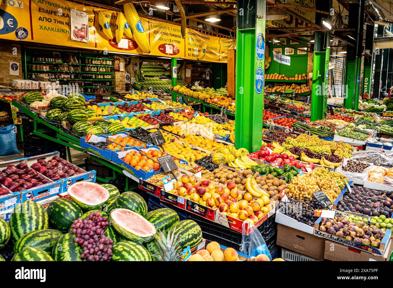 Assorted fruits and vegetables displayed in bins on shelves at an open ...