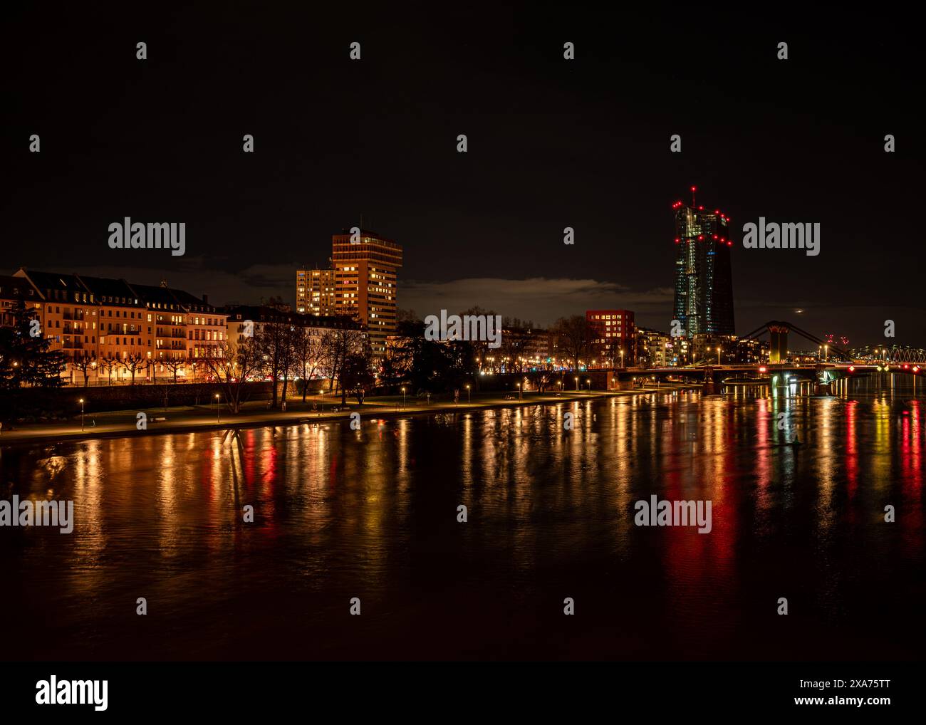 The city lights reflecting on the glowing river surface at night in ...