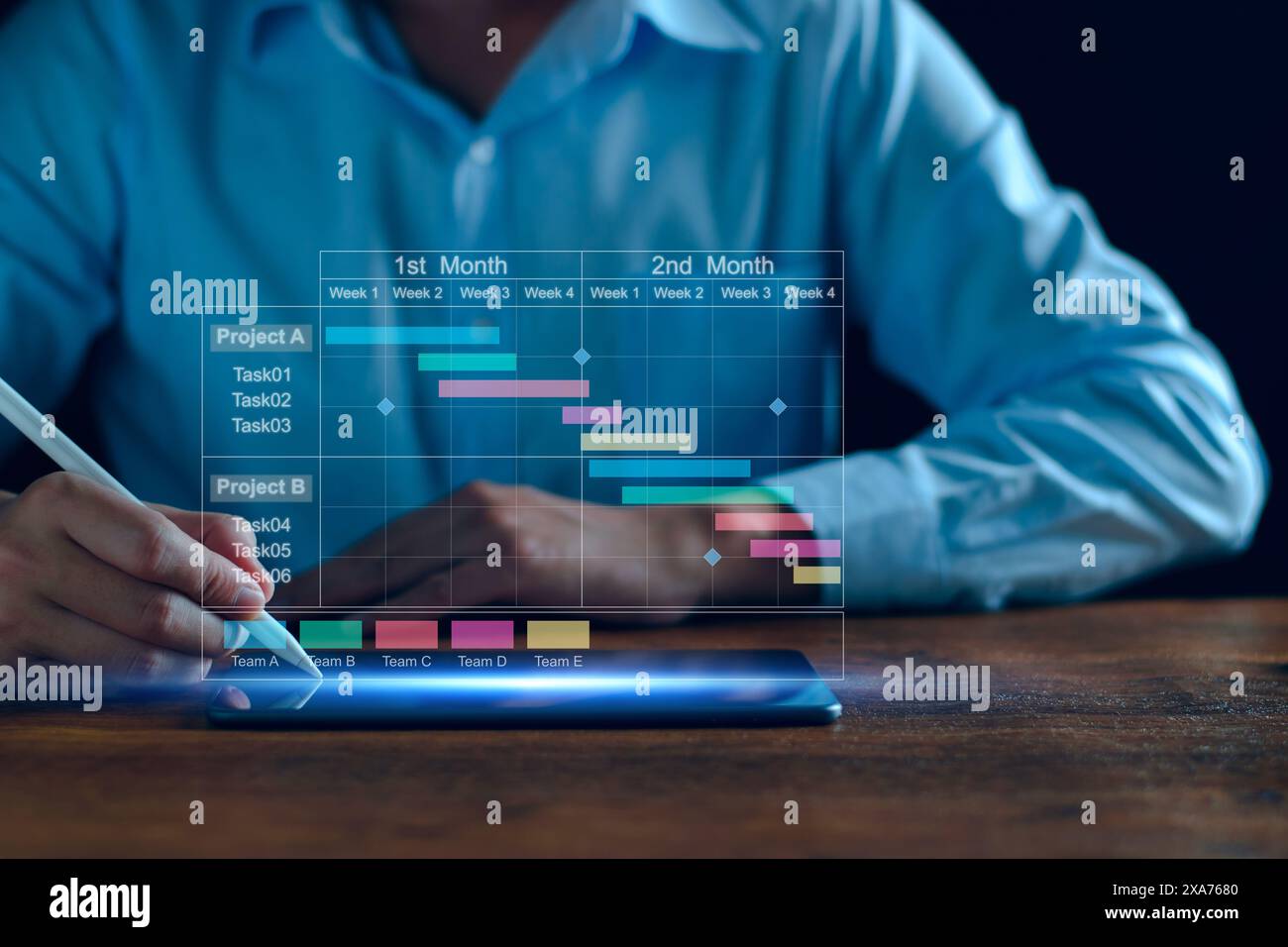Project manager working on tablet and updating tasks and milestones ...