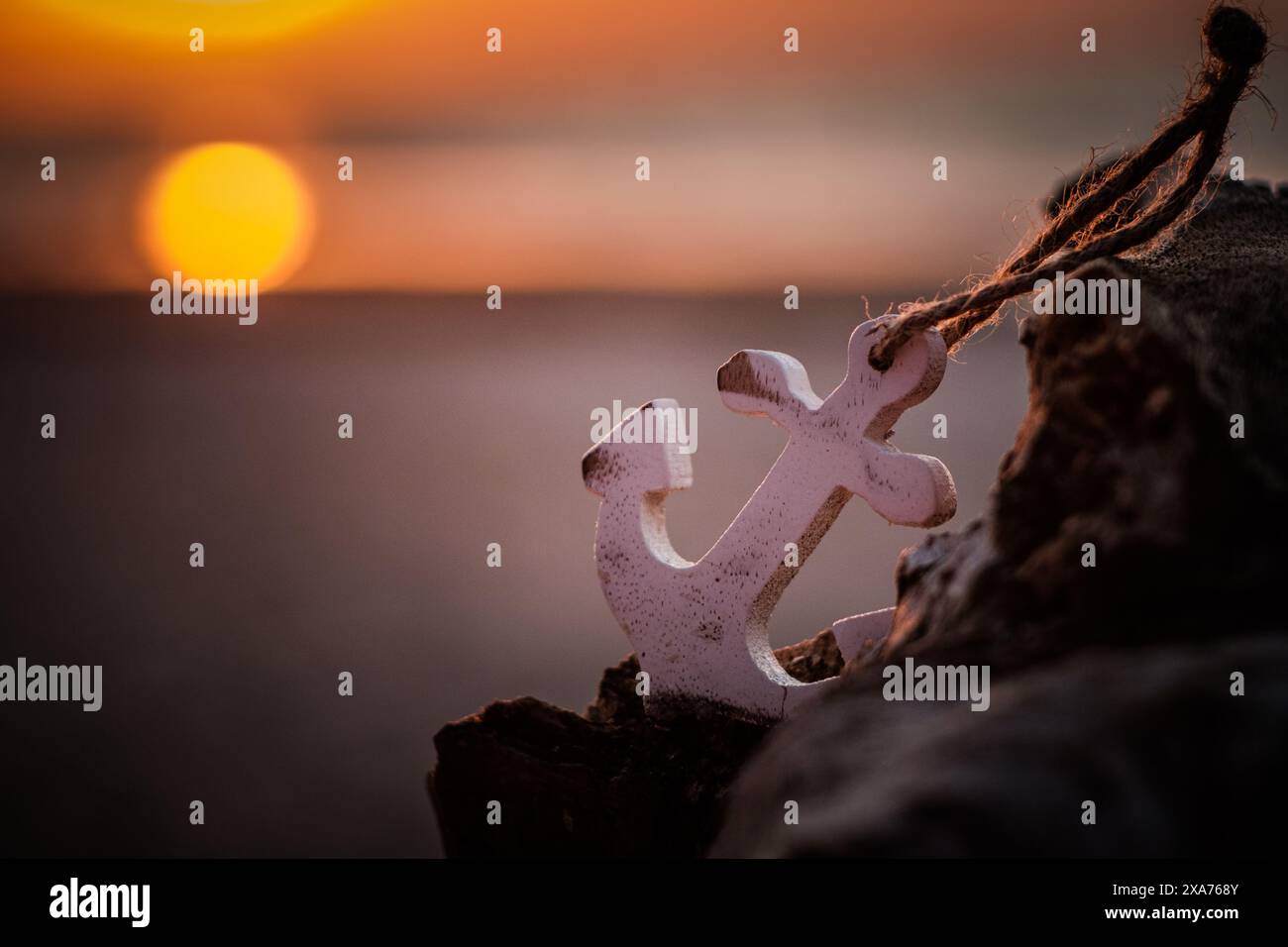 A wooden and white anchor resting on a log by the beach Stock Photo - Alamy
