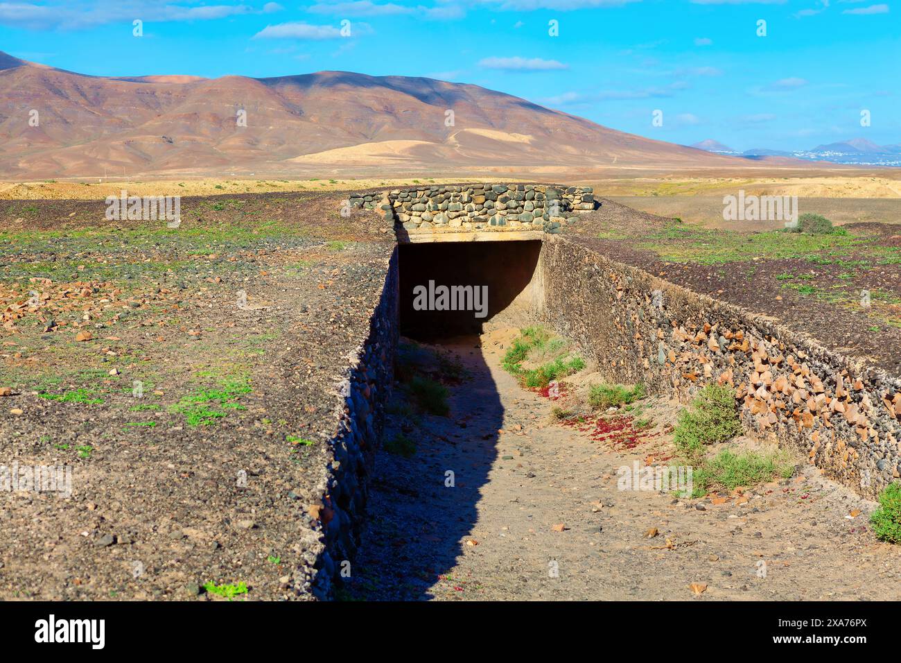 Tunnel carved through the desert landscape against mountains Stock ...