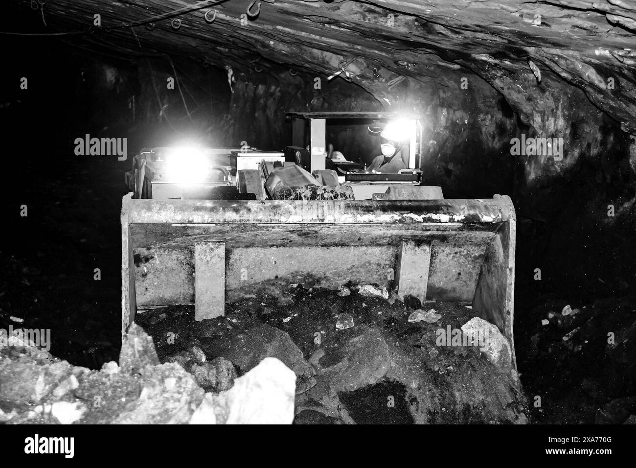A miner in protective gear with a shovel working underground Stock ...