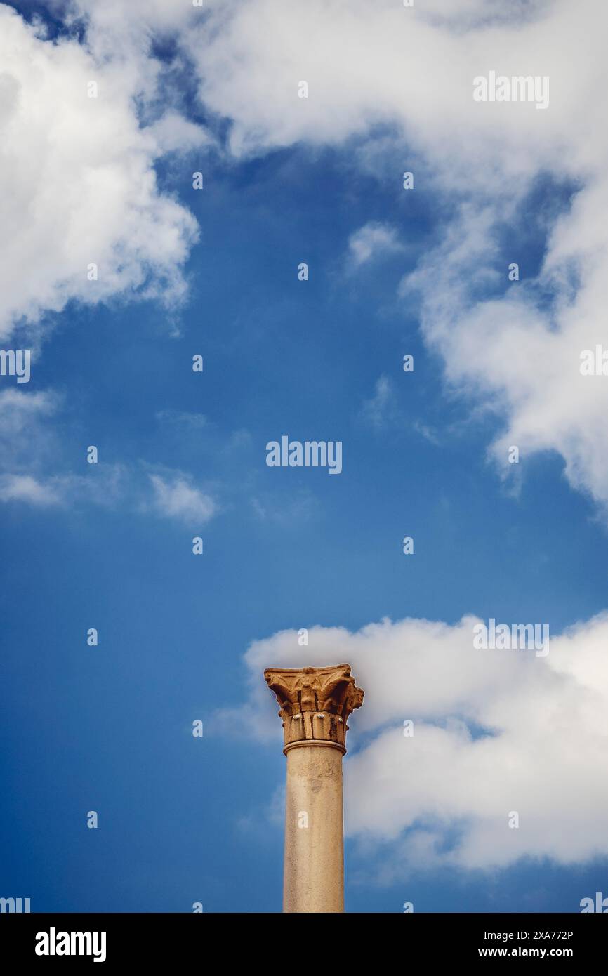 An ancient pillar rests under a blue, cloudy sky Stock Photo - Alamy