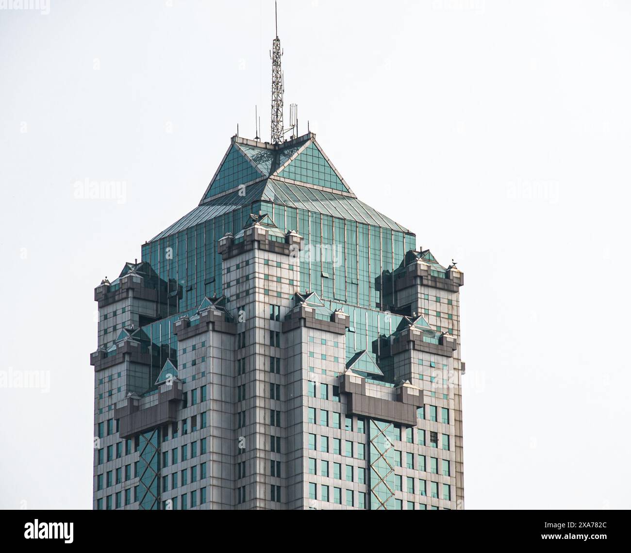 A Skyscraper with blue glass windows and a tower on top of it Stock ...