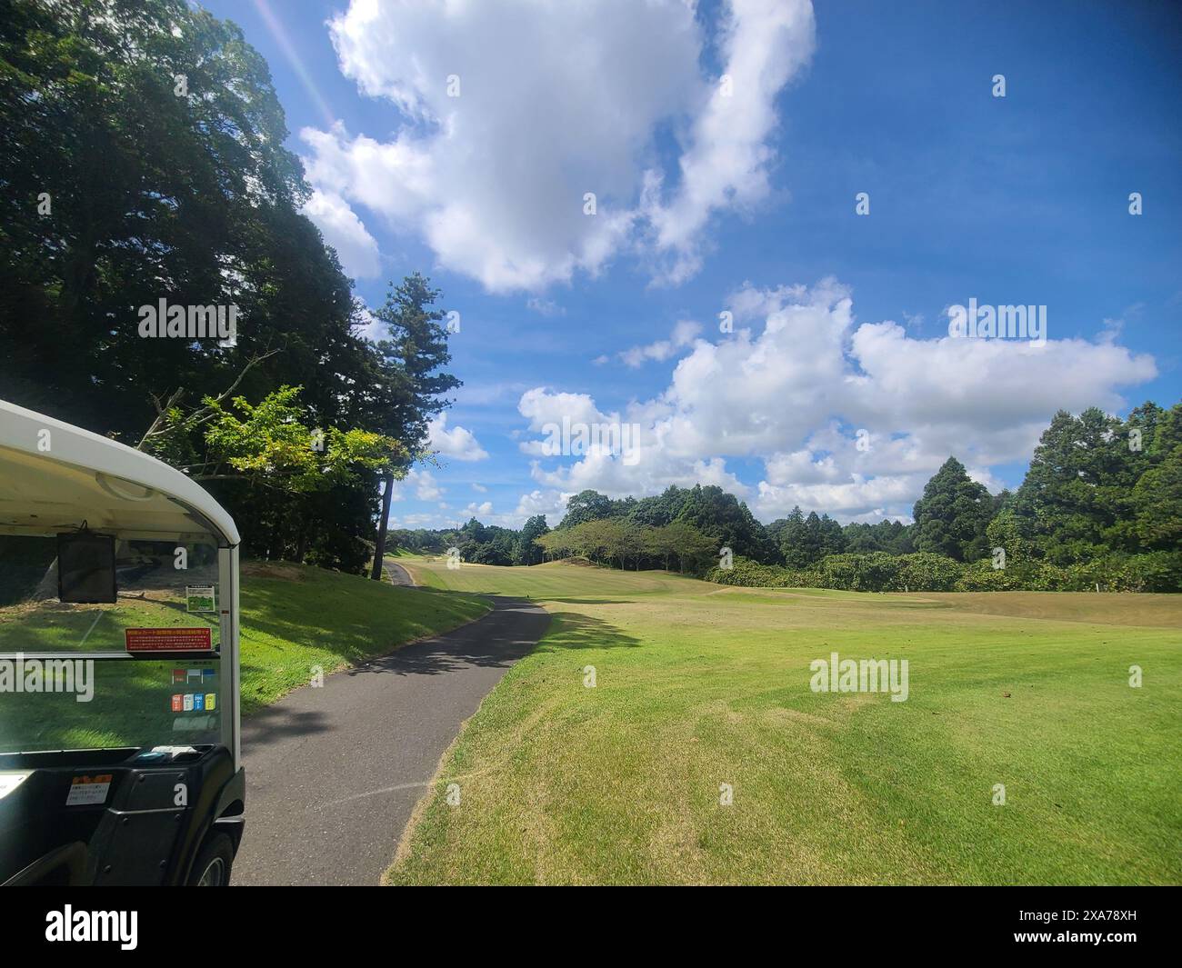 A golfer drives a golf cart on a dusty path Stock Photo - Alamy