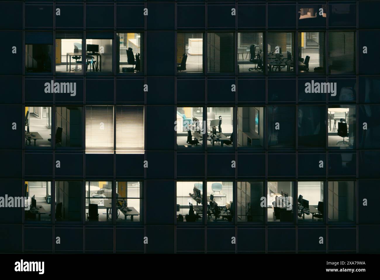 Looking in Illuminated empty office spaces in the skyscraper at night ...