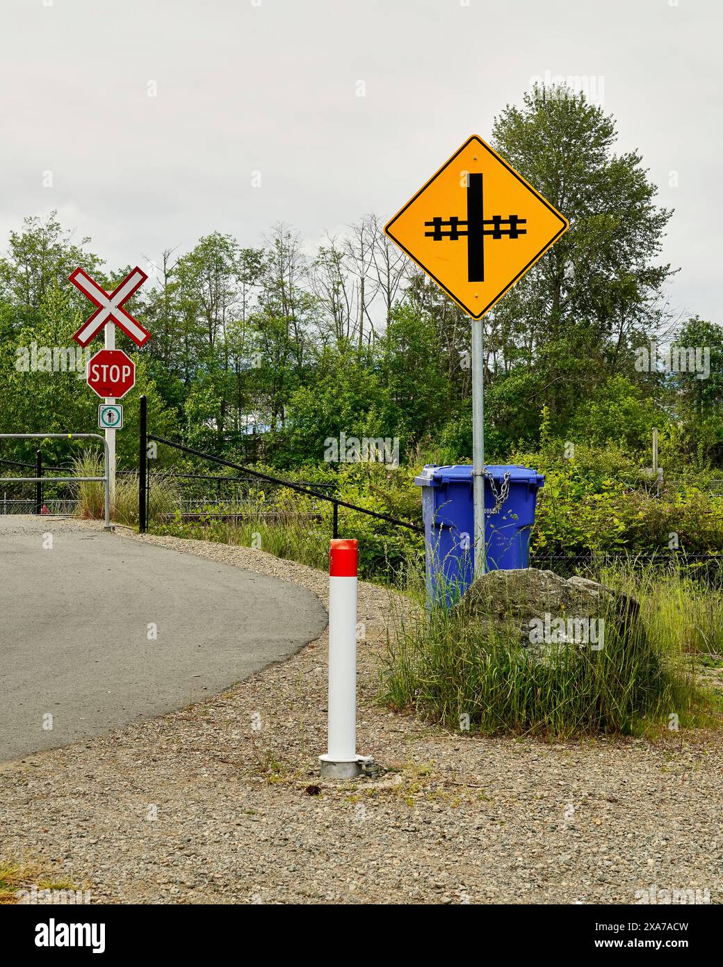 A pathway with signs indicating stop there is a railway crossing Stock ...