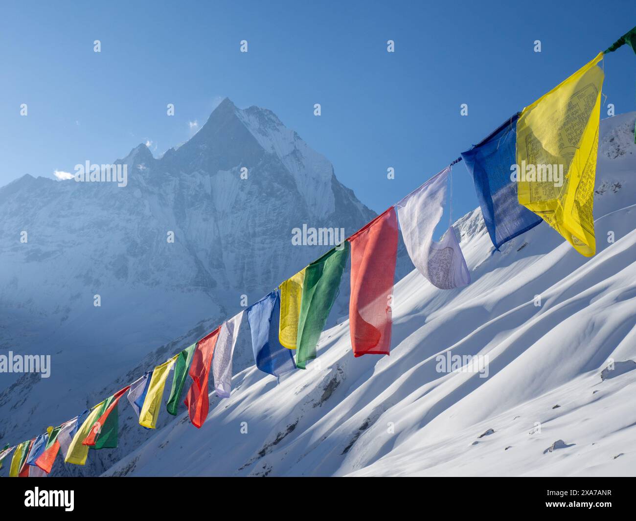 A snowy mountain peak adorned with colorful flags fluttering in the ...