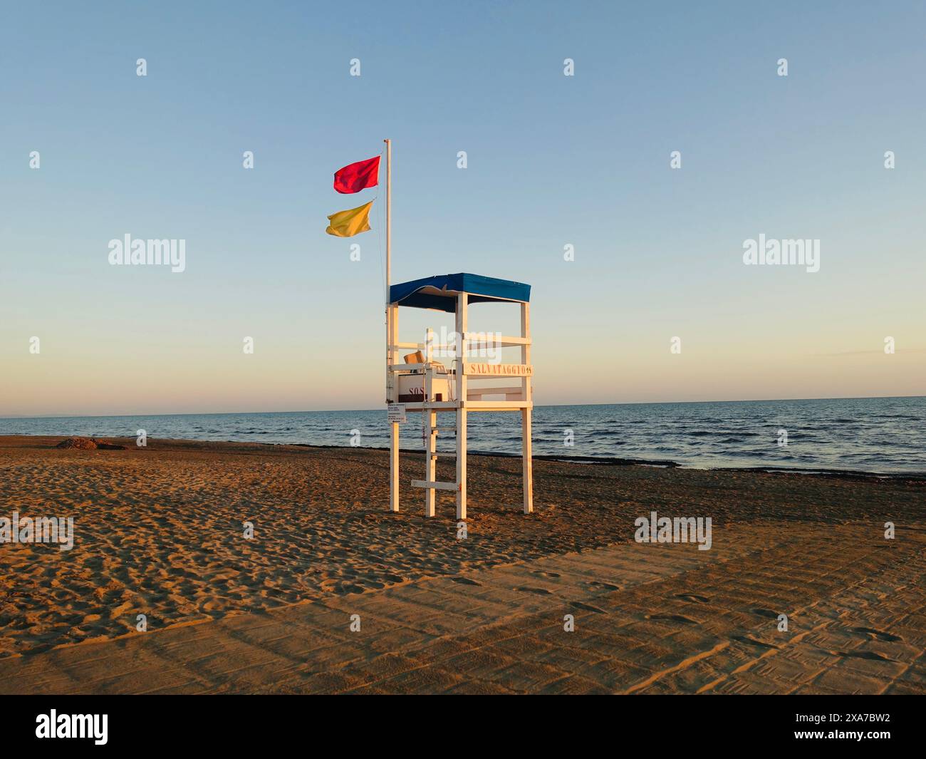 A lifeguard stand on the beach against the sea at sunset Stock Photo ...