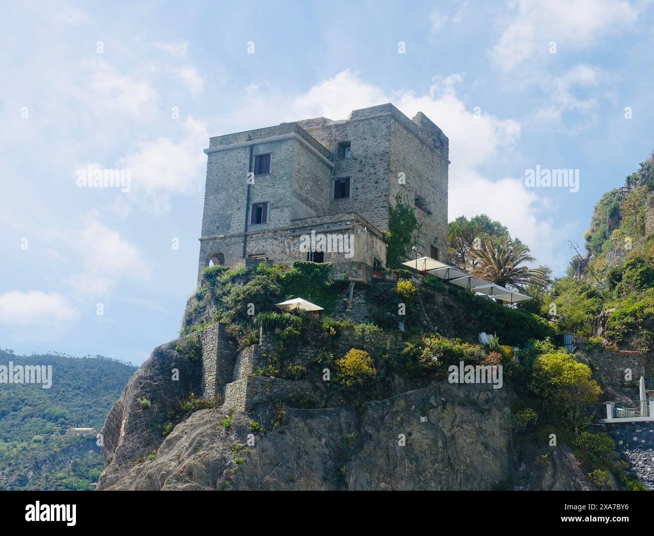 A massive cliffside building with a beach nestled inside Stock Photo ...