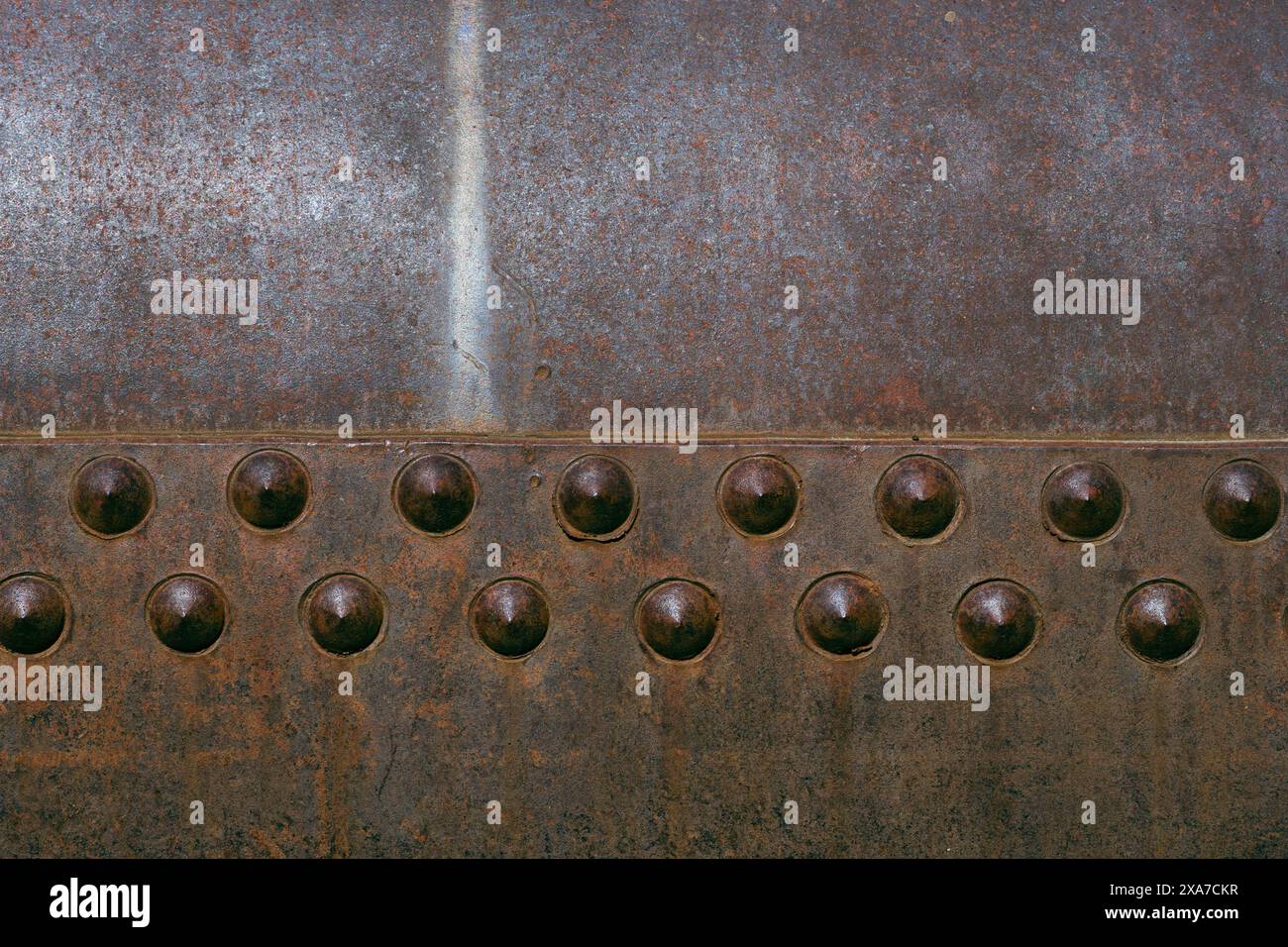 A rusty metal panel with rivets and perforations Stock Photo - Alamy