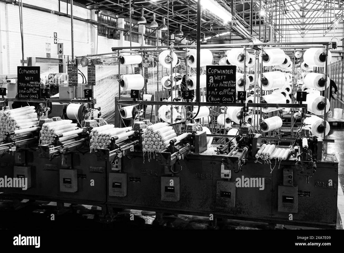 A monochrome of cotton thread bobbin on a cop winder weft assembly line ...