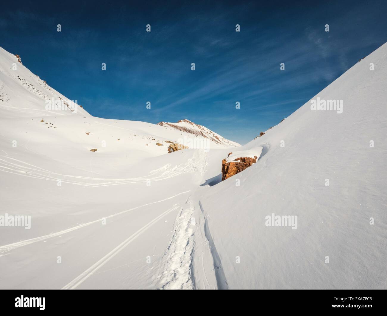 Mountain hilly winter landscape with traces of hiking trails and skis ...